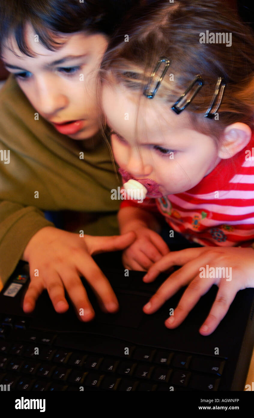 brother helping younger sister on computer Stock Photo - Alamy