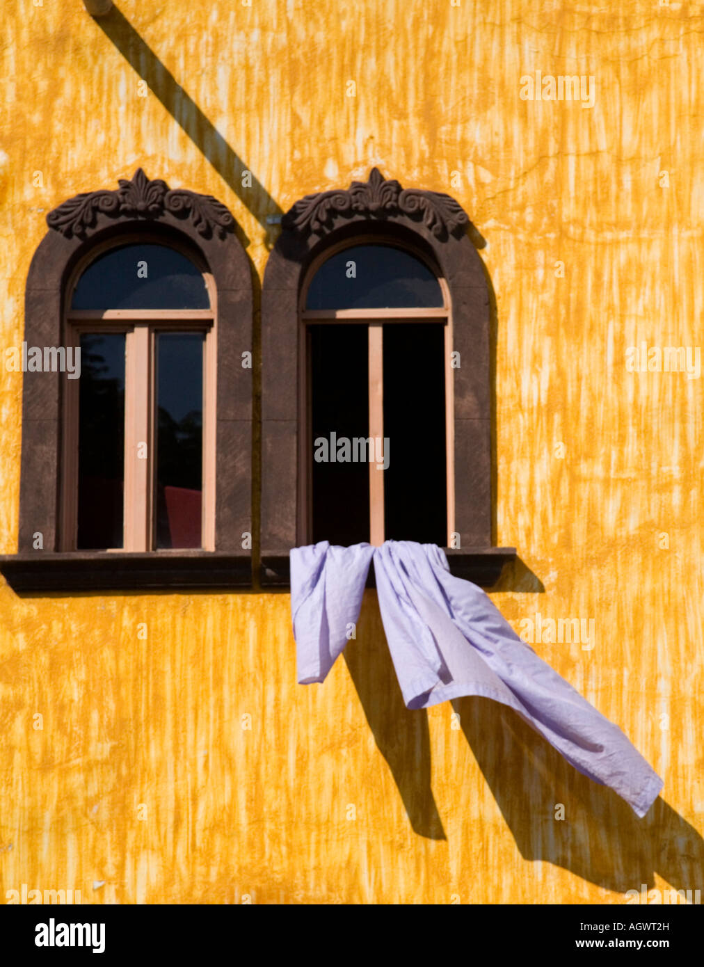 Lavender sheet hanging out of window Stock Photo - Alamy