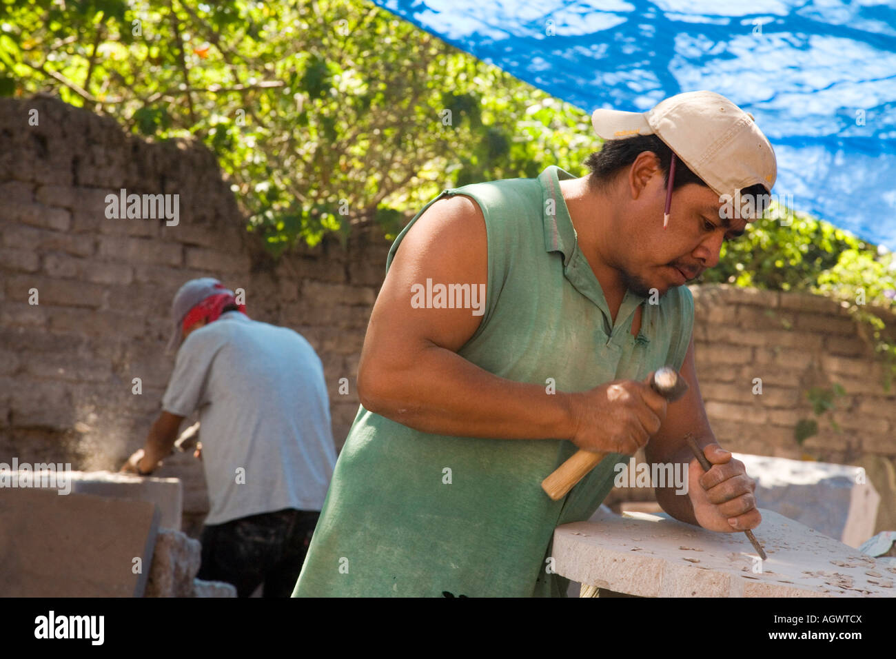 Hispanic stone carving workers using hammers and chisels Stock Photo ...