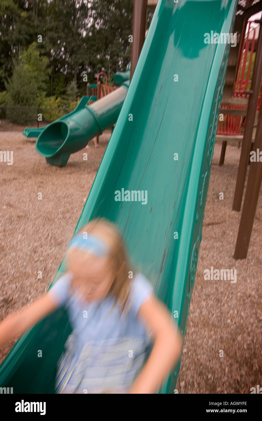 Child going down a playground slide Stock Photo - Alamy