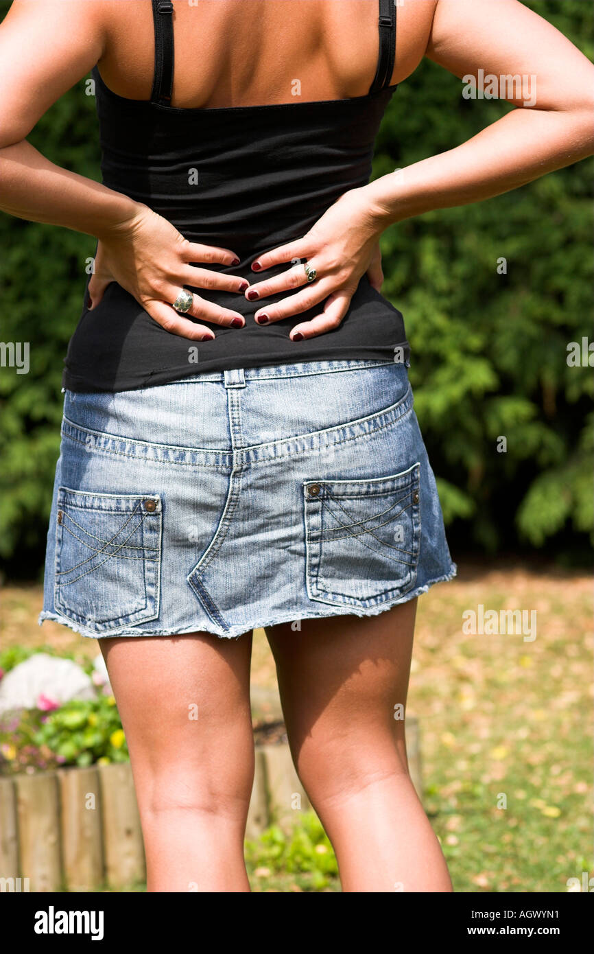 Woman with hands resting on her back Stock Photo - Alamy