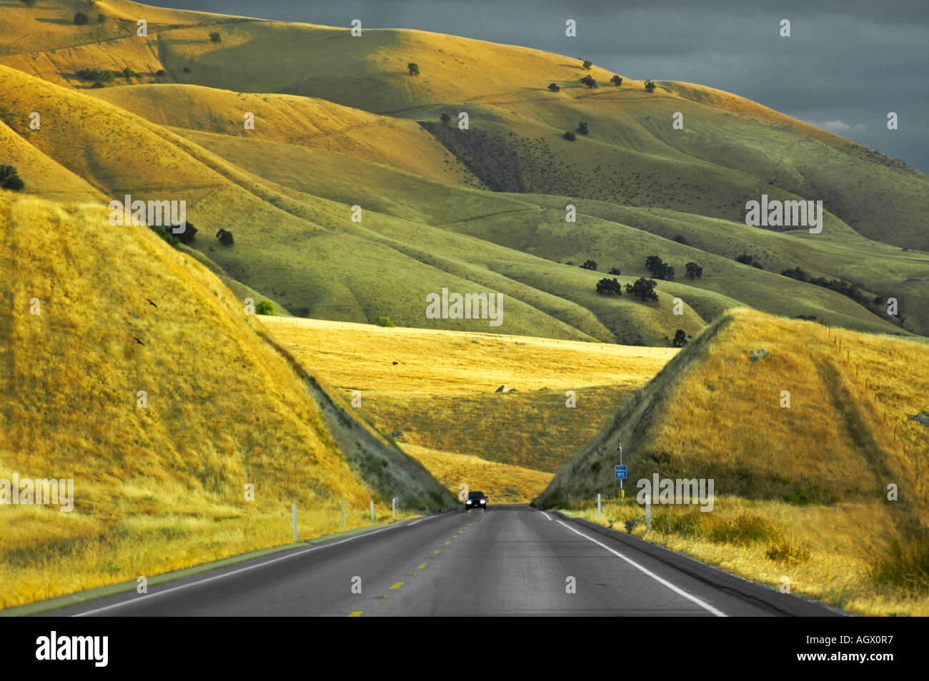 Middle of the road photo of a highway cutting through a mountain pass ...