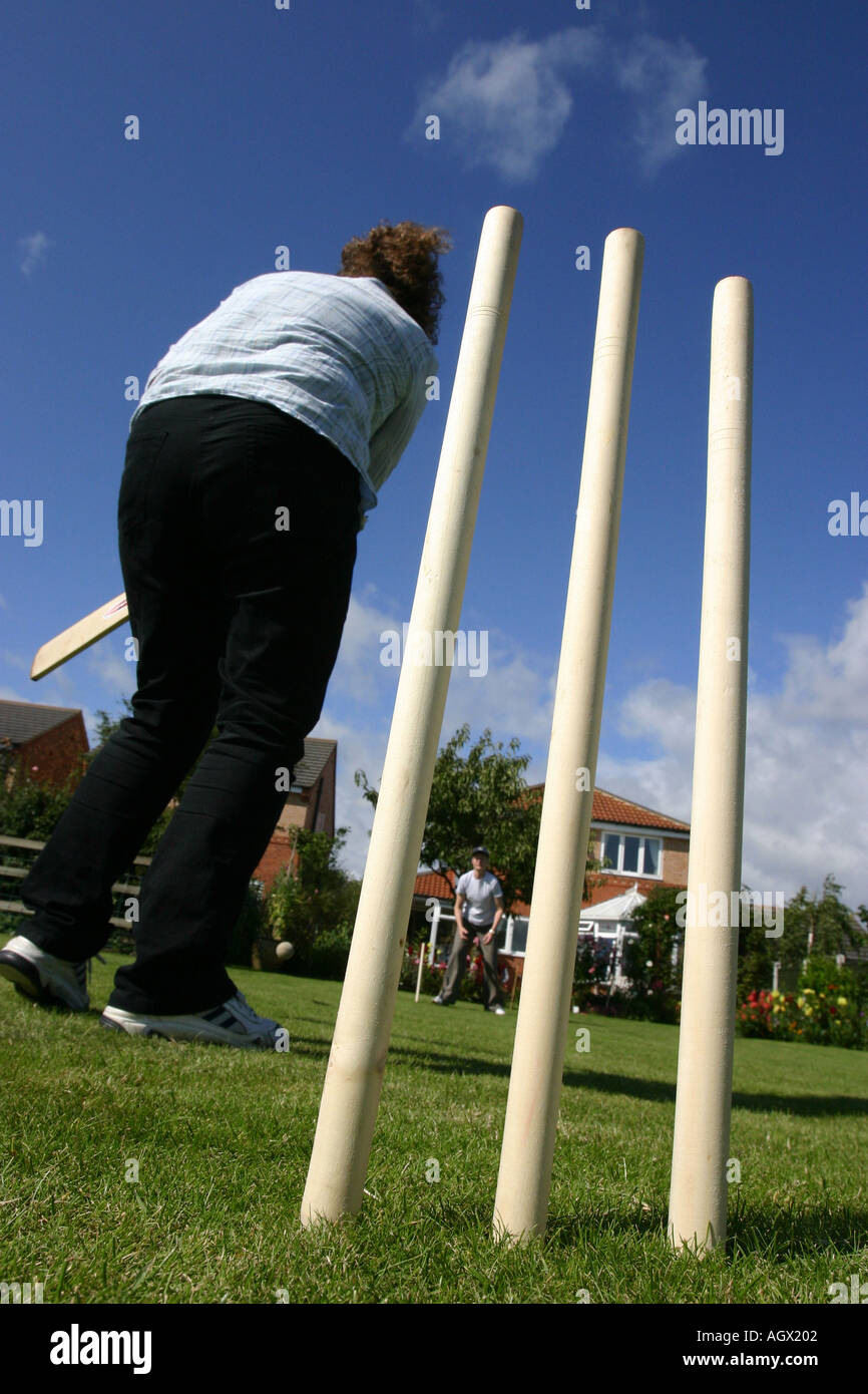 Adults playing cricket in a garden A family in summer Stock Photo - Alamy