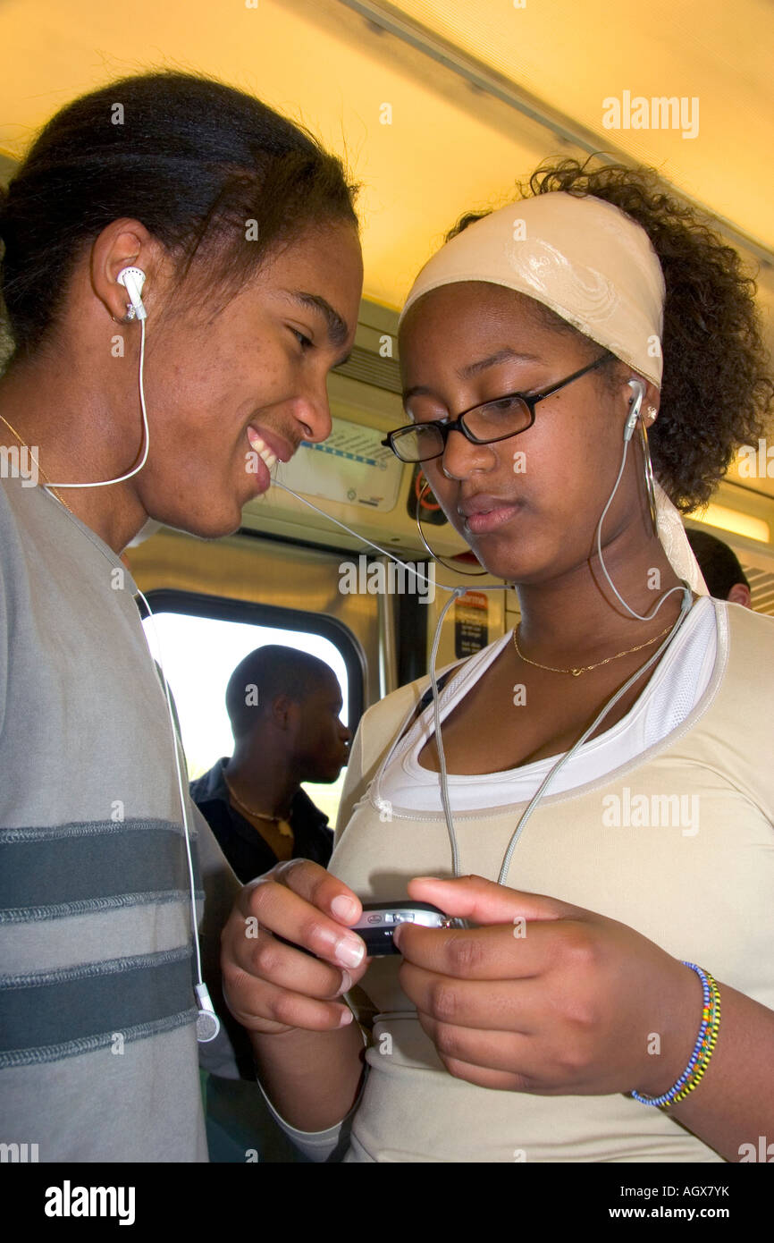 French students listen to an MP3 player on the train in Paris France ...