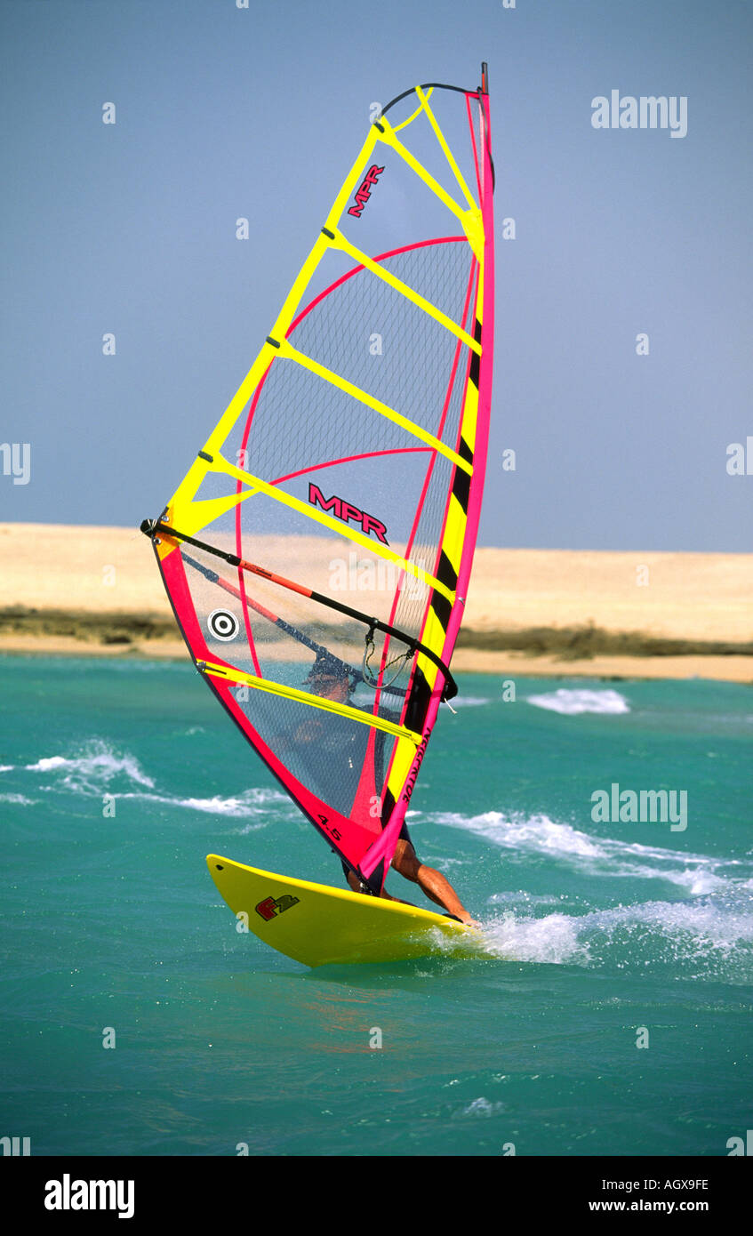 Solo adult windsurfer performing a gybe turn at speed on the Red Sea at ...