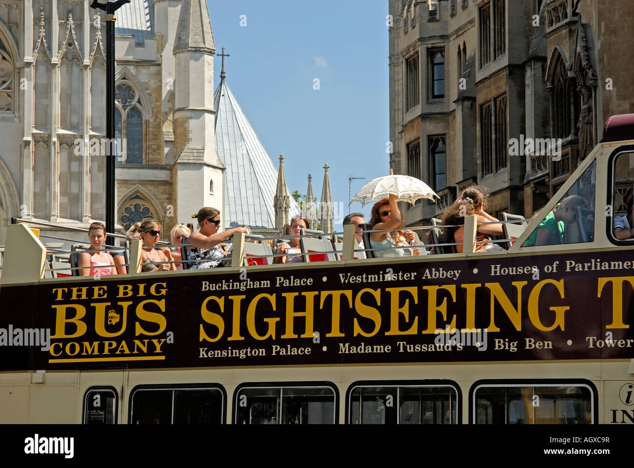 close-up of open-top deck of sightseeing bus with sightseers outside ...
