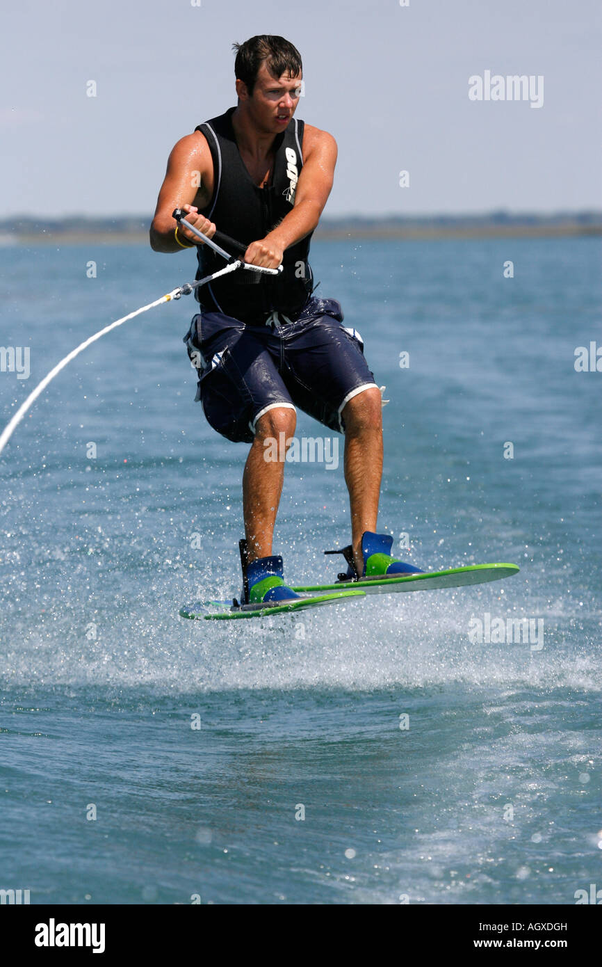 Teenage boy jumping with trick waterskis Stock Photo - Alamy