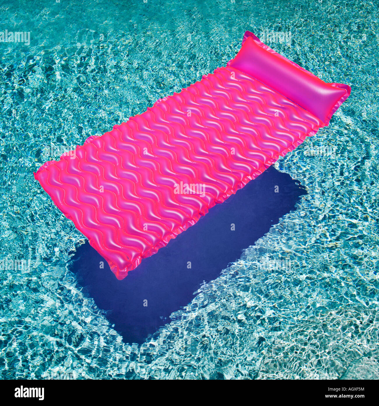 Pink float in empty swimming pool with rippling blue pool Stock Photo ...