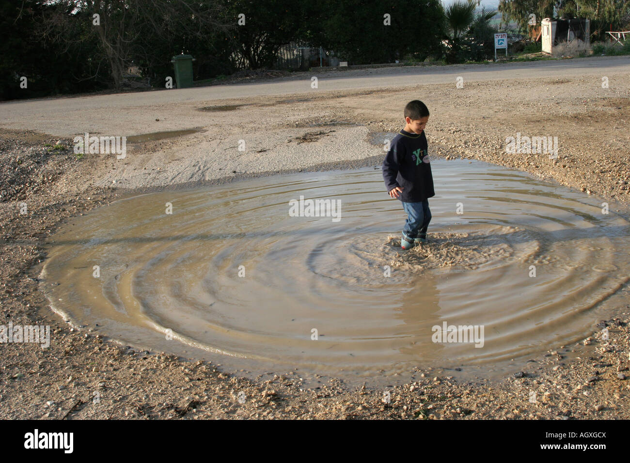 Boy playing in puddle Stock Photo - Alamy