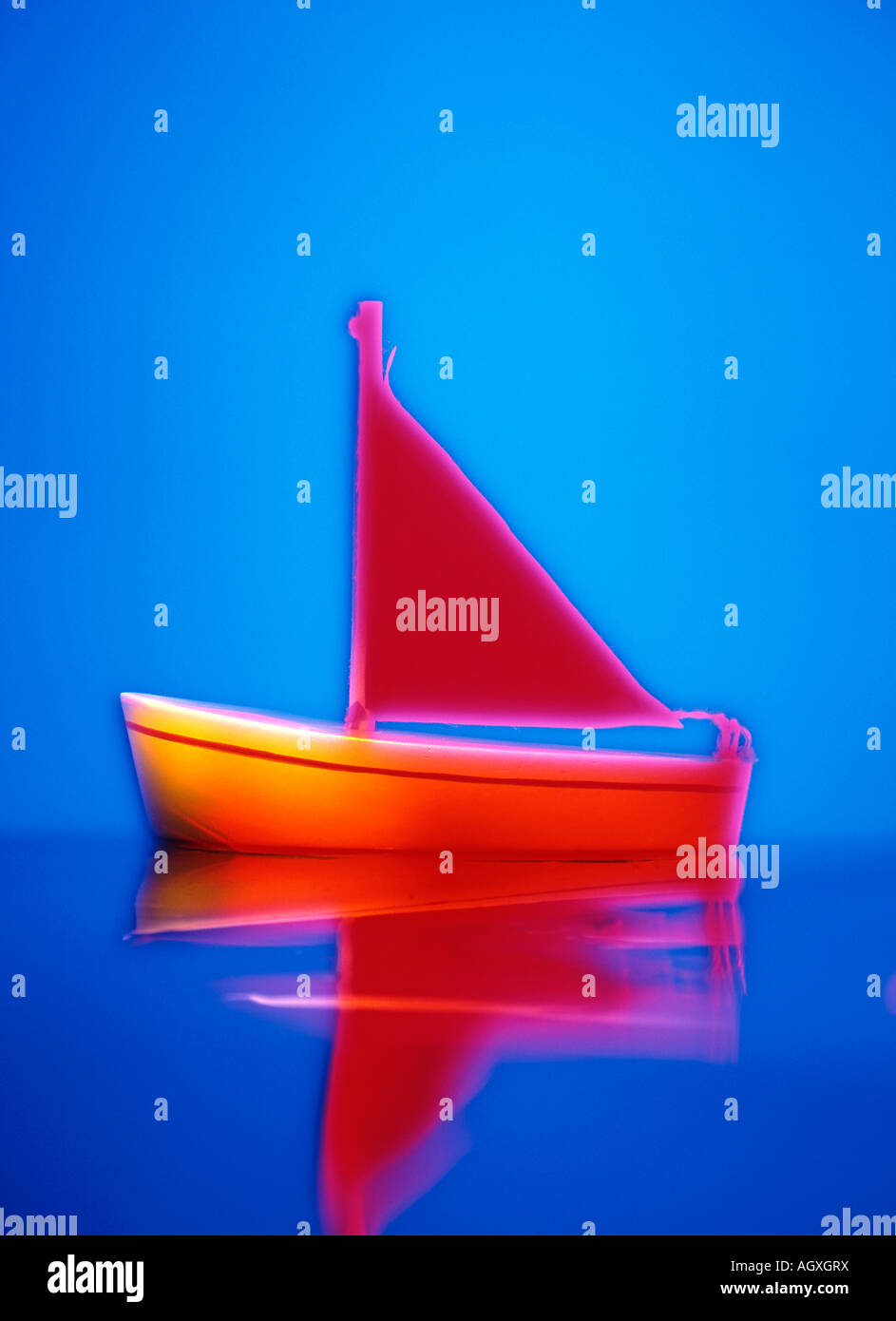toy yacht red sail yellow hull blue water Stock Photo - Alamy