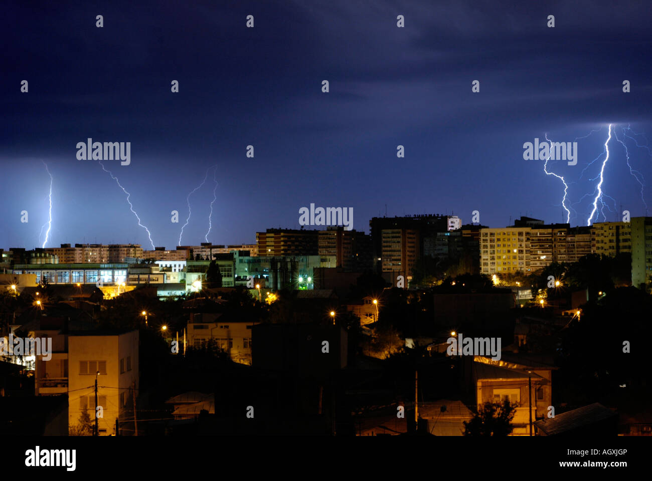 Lightning over city at dusk Stock Photo - Alamy