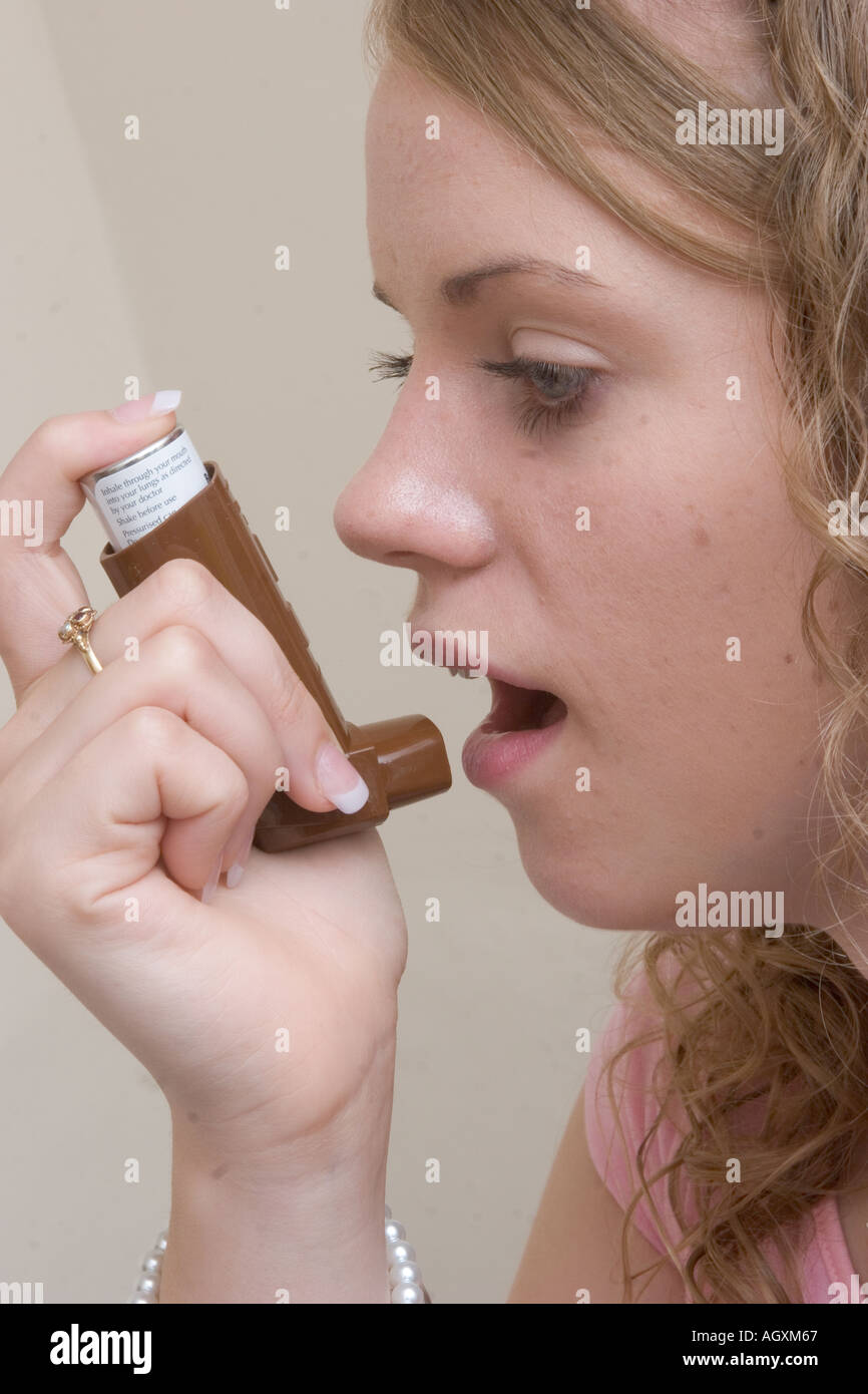 Pretty blond teenager using asthma Becotide inhaler Stock Photo - Alamy