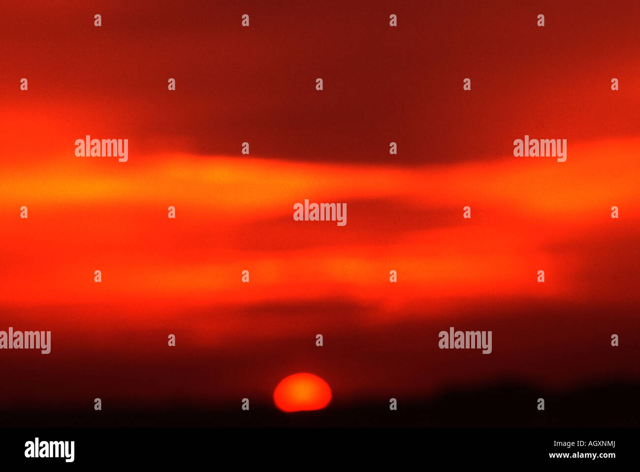 Orange sky with the sun setting Stock Photo - Alamy