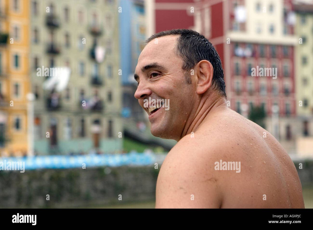 Man smiles as he prepares to walk along greasy pole over river Bilbao ...