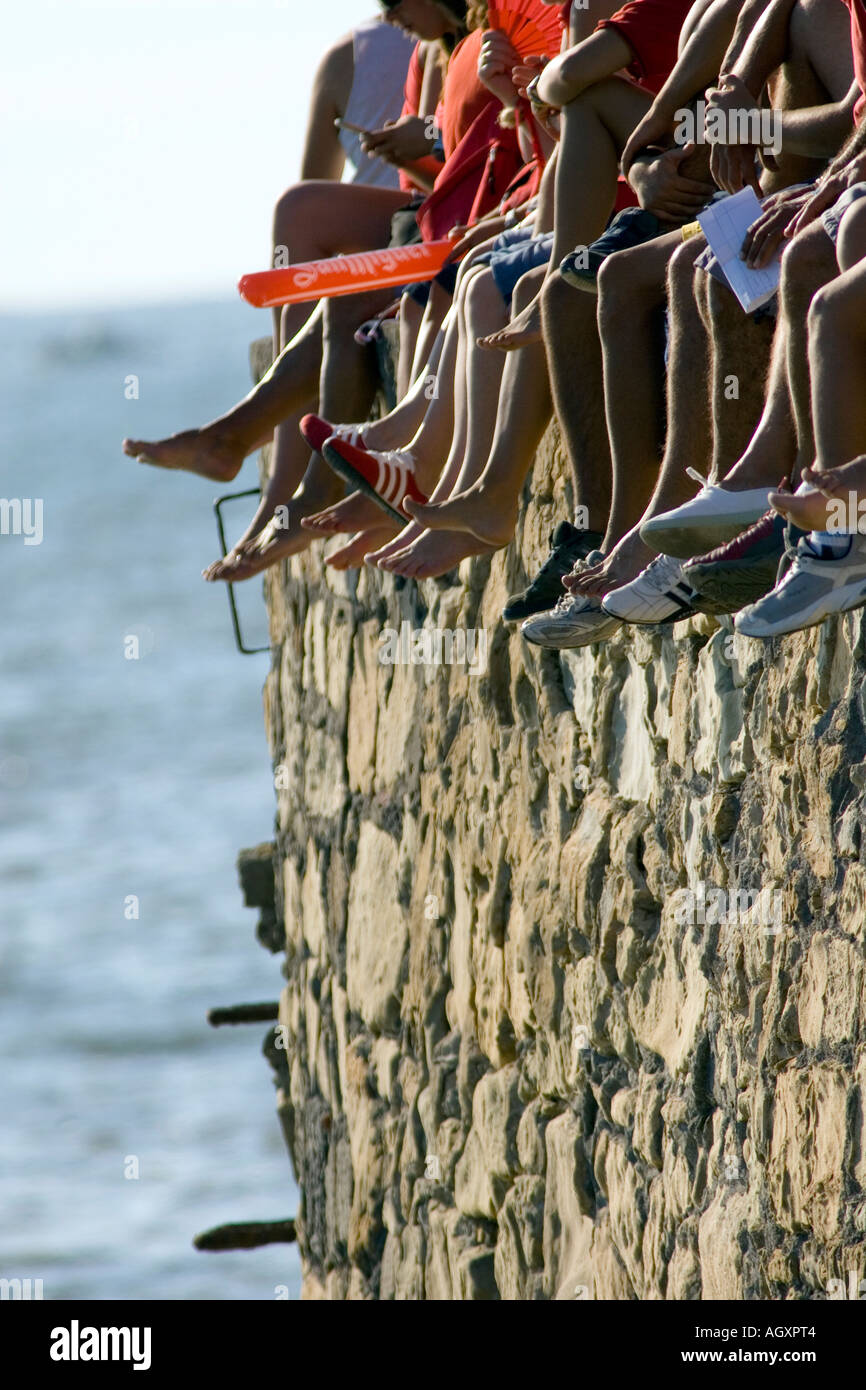 Legs and feet of spectators watching traineras regatta sitting on sea ...