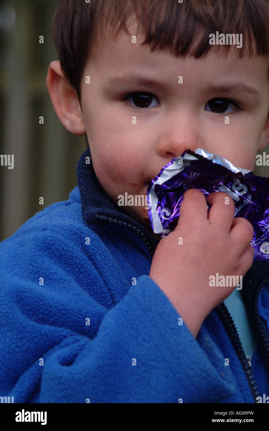 Little boy eating a chocolate bar Stock Photo - Alamy