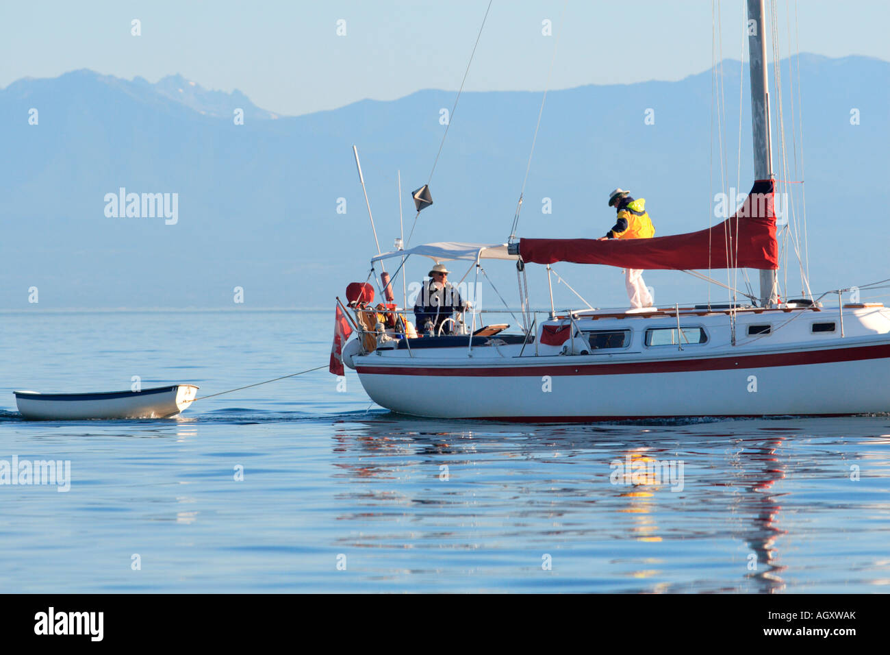 sail boat trailing life boat heading to dock Stock Photo - Alamy