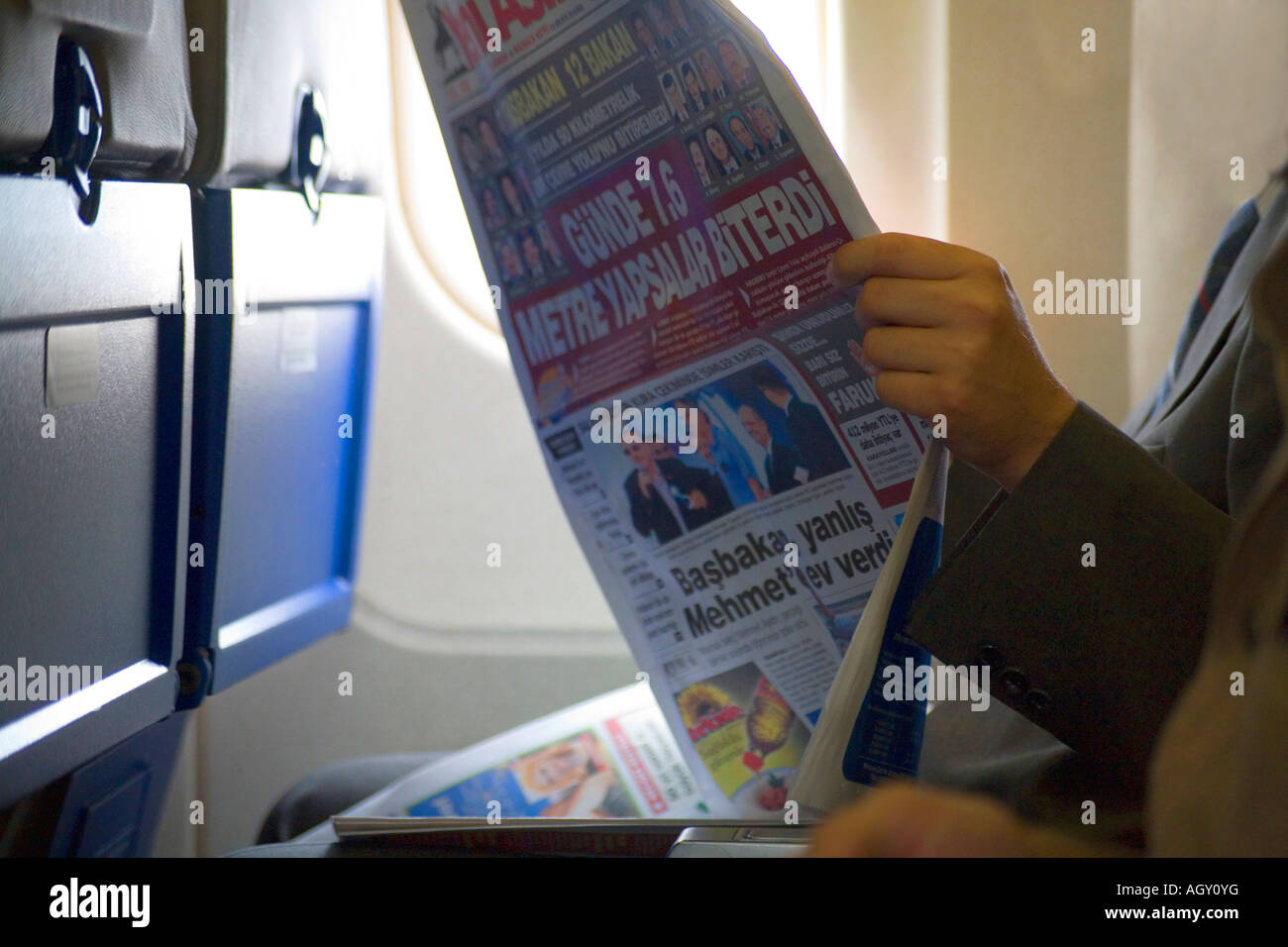 Man reading Turkish newspaper on airplane Stock Photo - Alamy