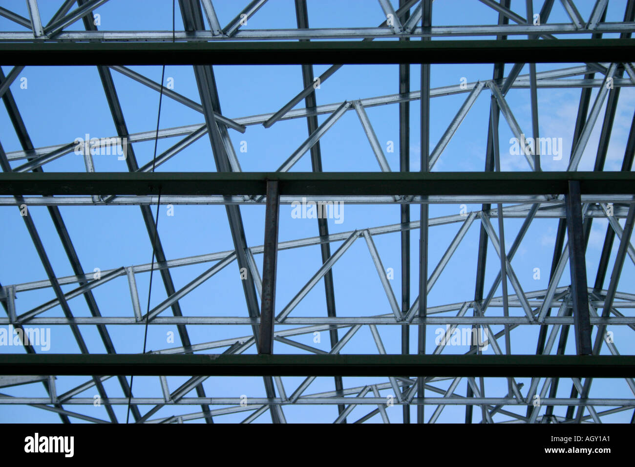 skeletal frame of a partially constructed building against blue sky ...