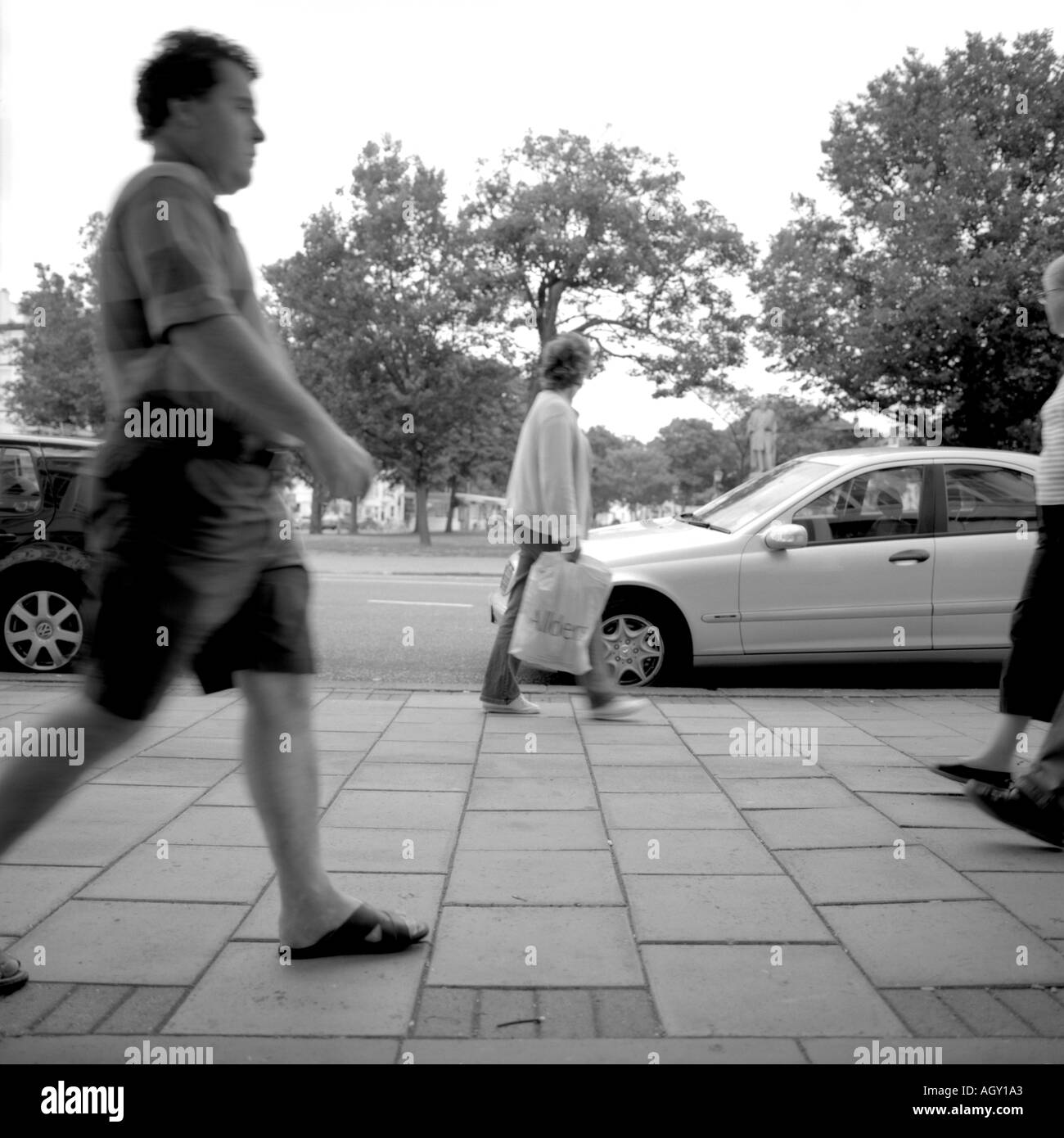 Monochrome man walking on pavement Stock Photo - Alamy