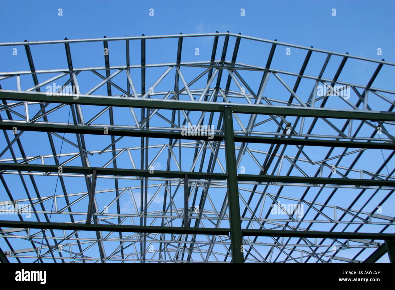 skeletal frame of a partially constructed building against blue sky ...