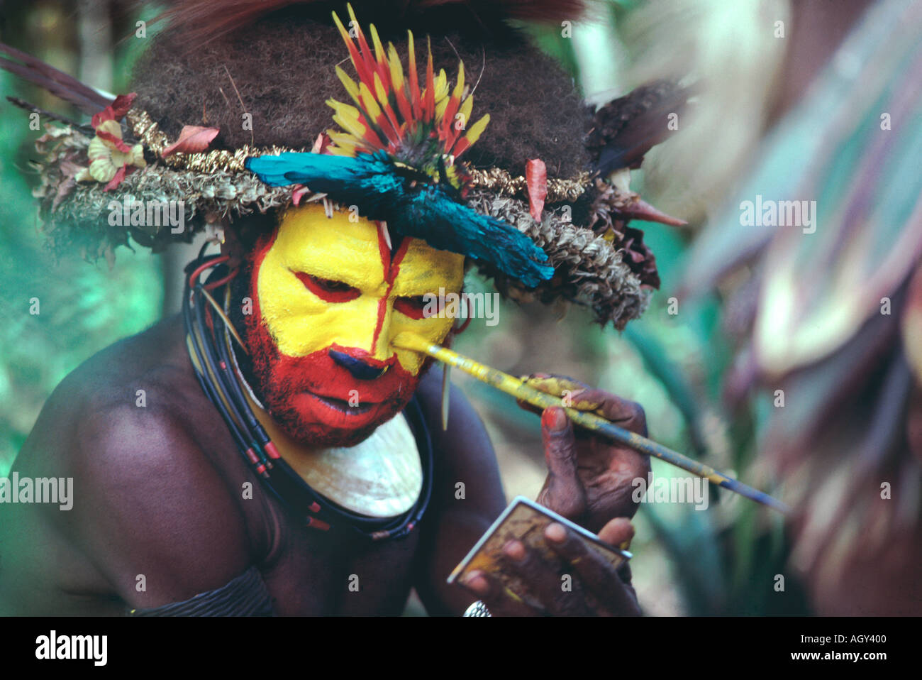 Huli wigman painting face for sing sing in a village near Tari in the ...