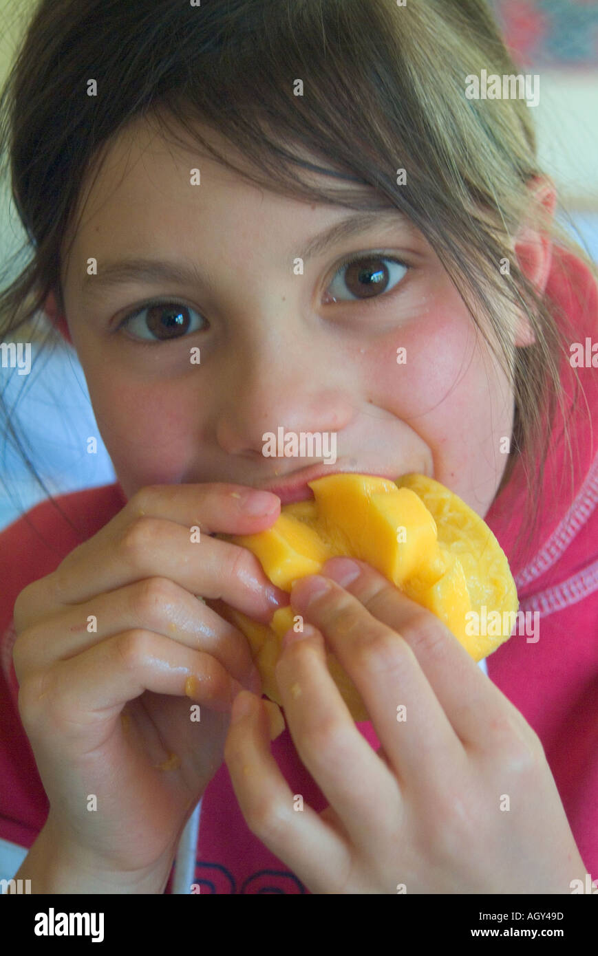 Young girl eating mango hi-res stock photography and images - Alamy