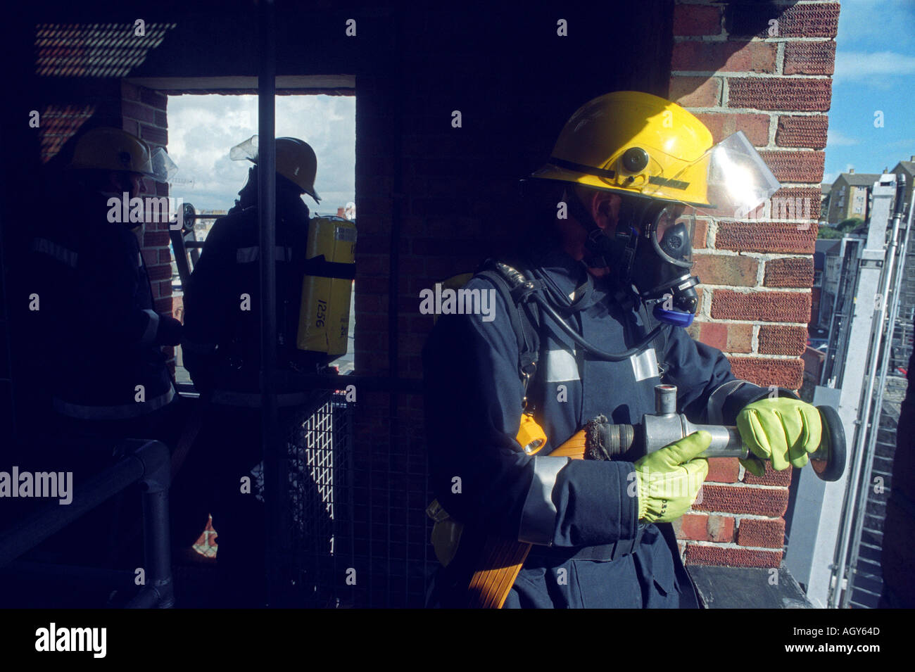 A Firefighter using a hose reel jet, Britain UK Stock Photo - Alamy