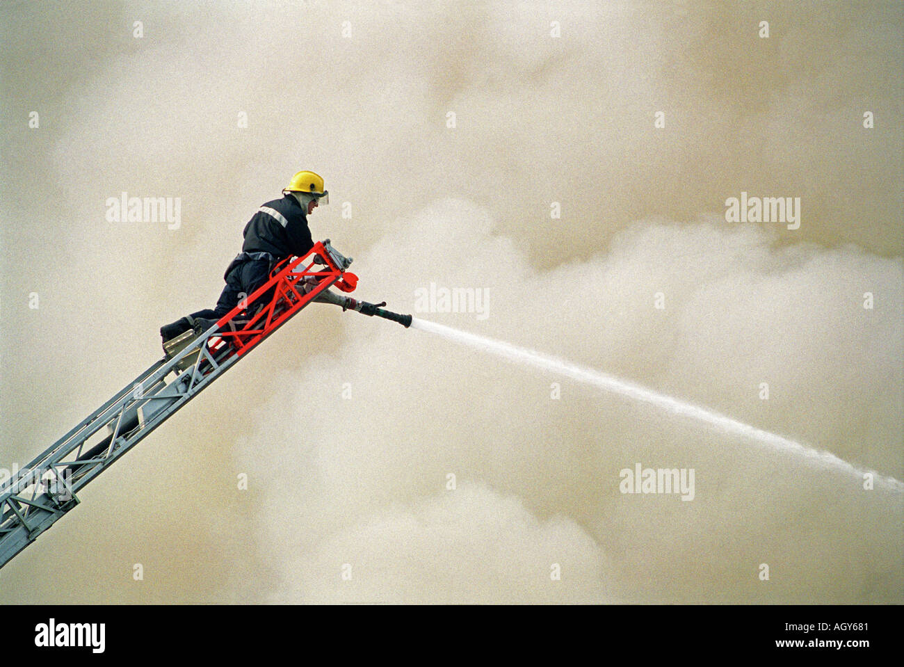 Firefighter in action at the top of a hydraulic ladder, Britain UK ...