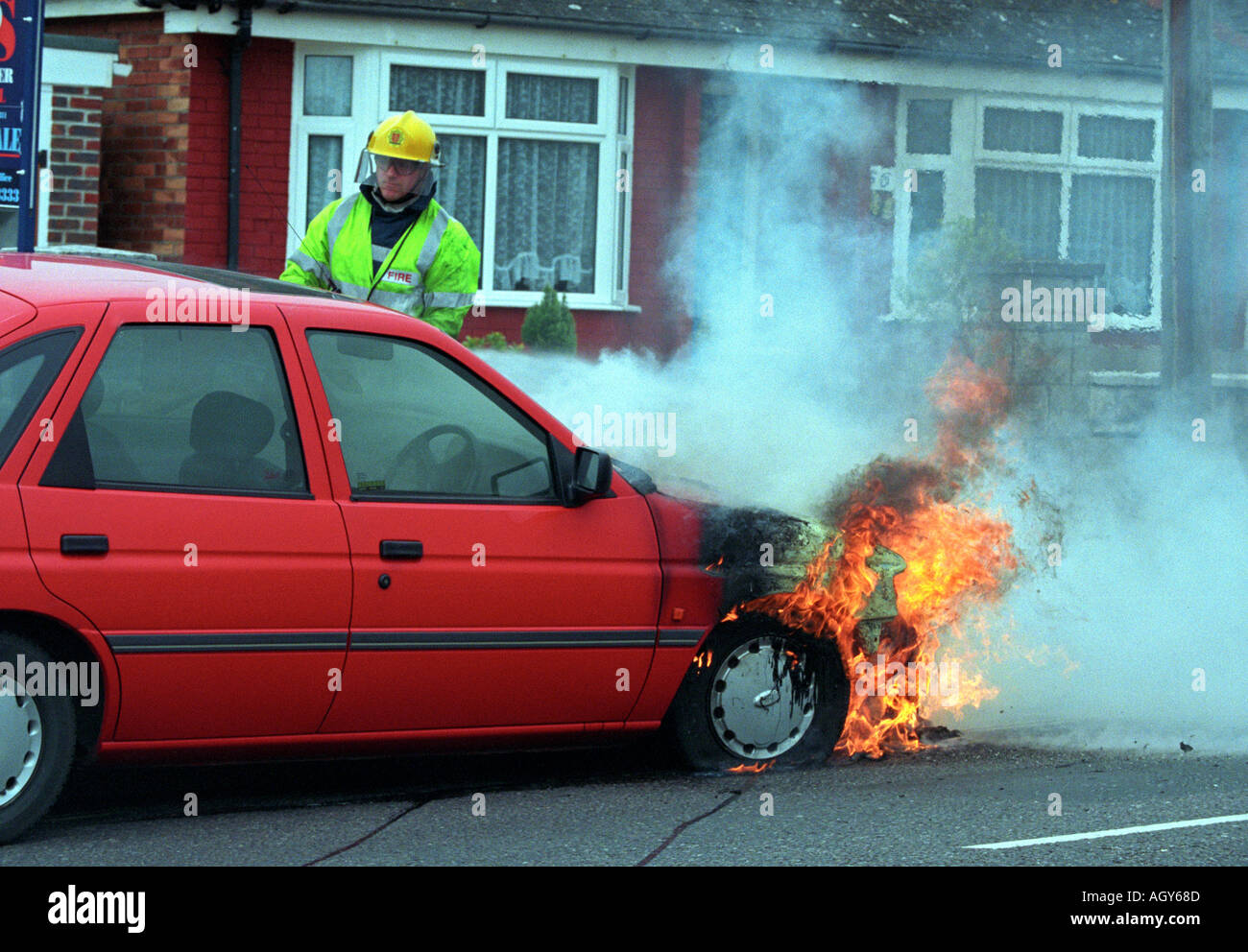 Firefighter putting out a car fire, Britain UK Stock Photo - Alamy