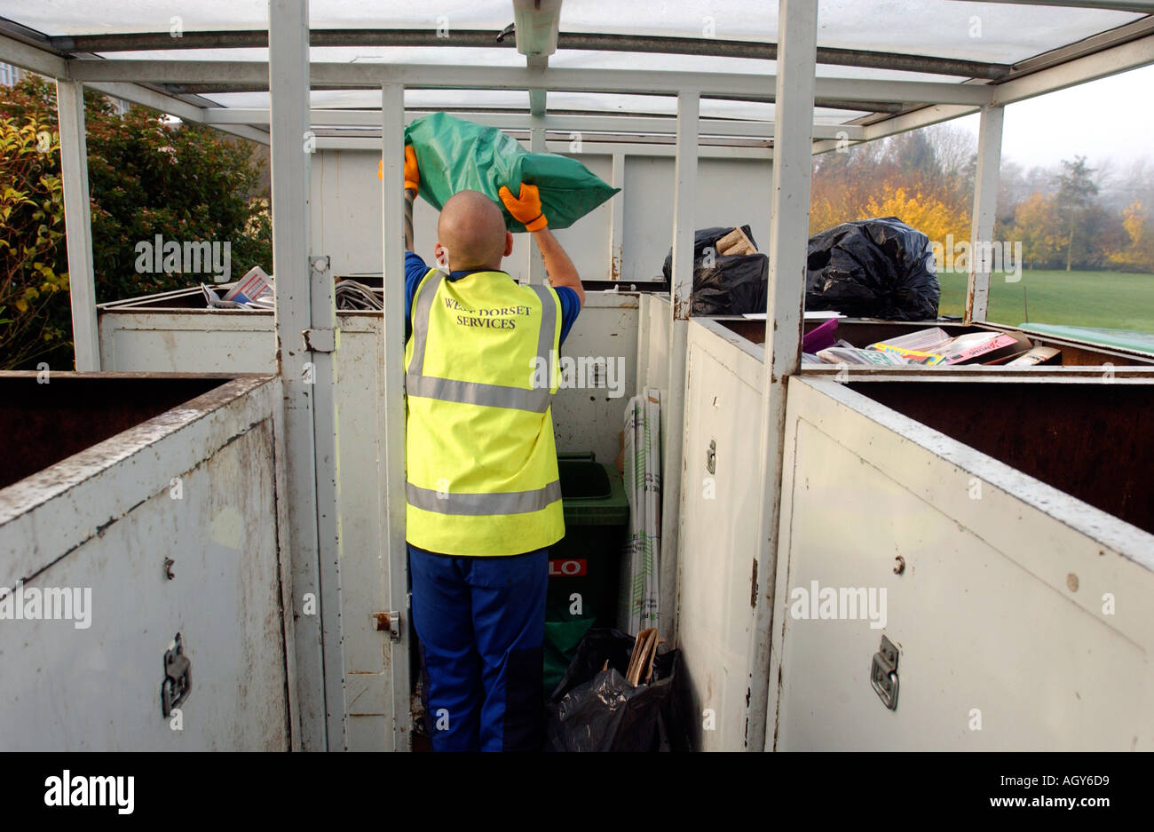 Council worker sorting rubbish for recycling in the collection lorry ...