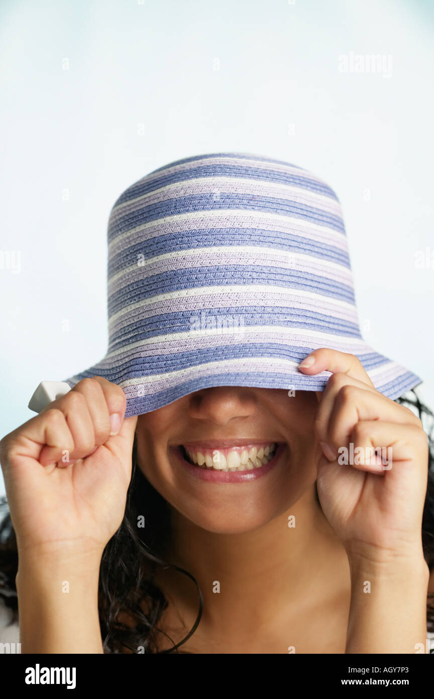 Close up of woman smiling while pulling hat down over her eyes Stock ...