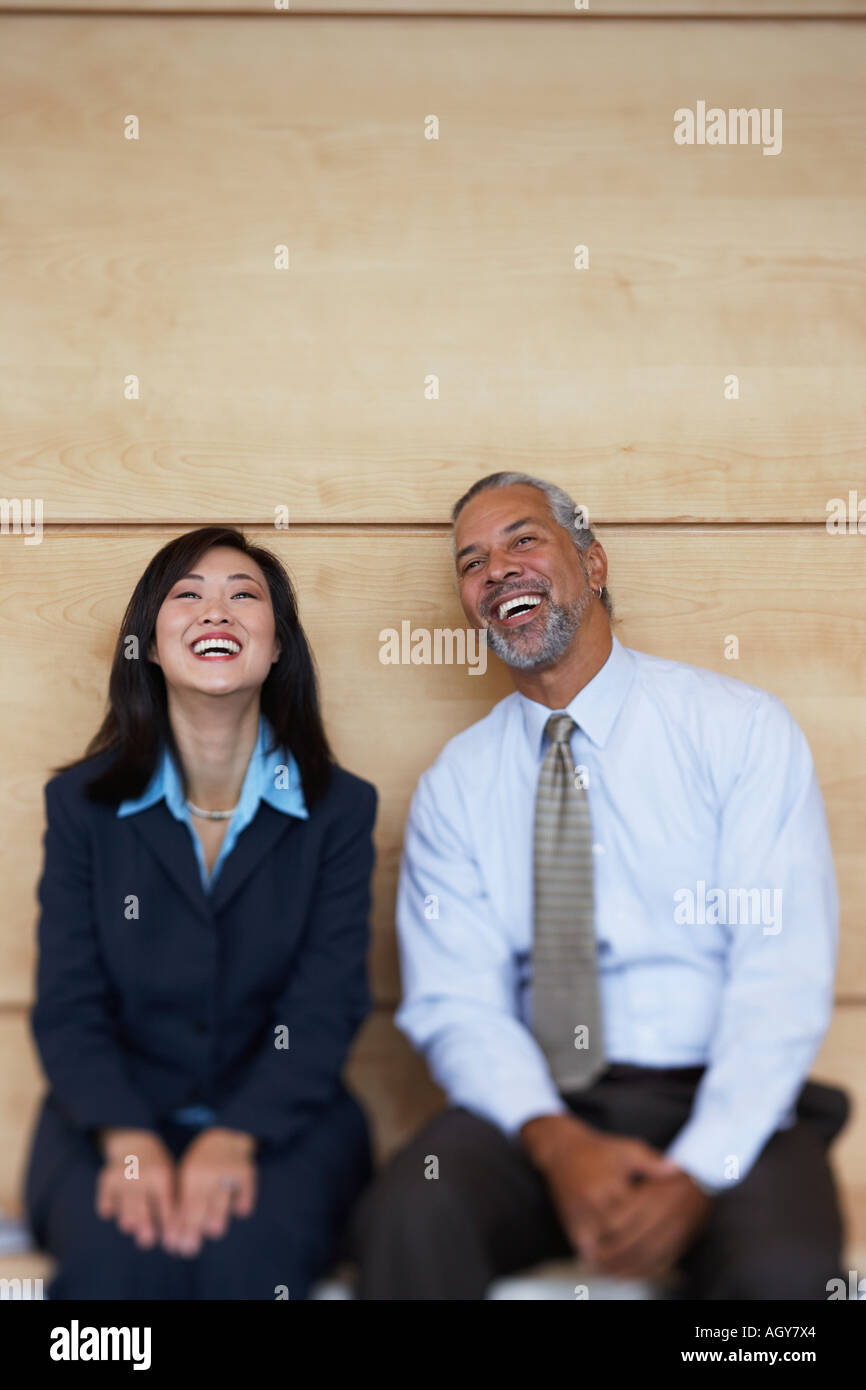 Two co workers sitting and laughing Stock Photo - Alamy