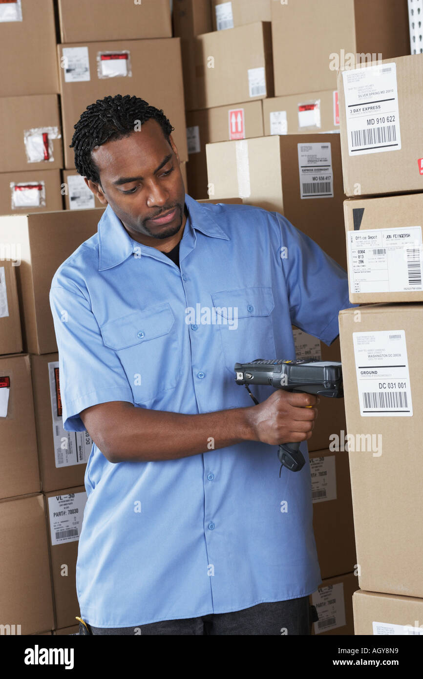 Male African warehouse worker scanning packages Stock Photo - Alamy