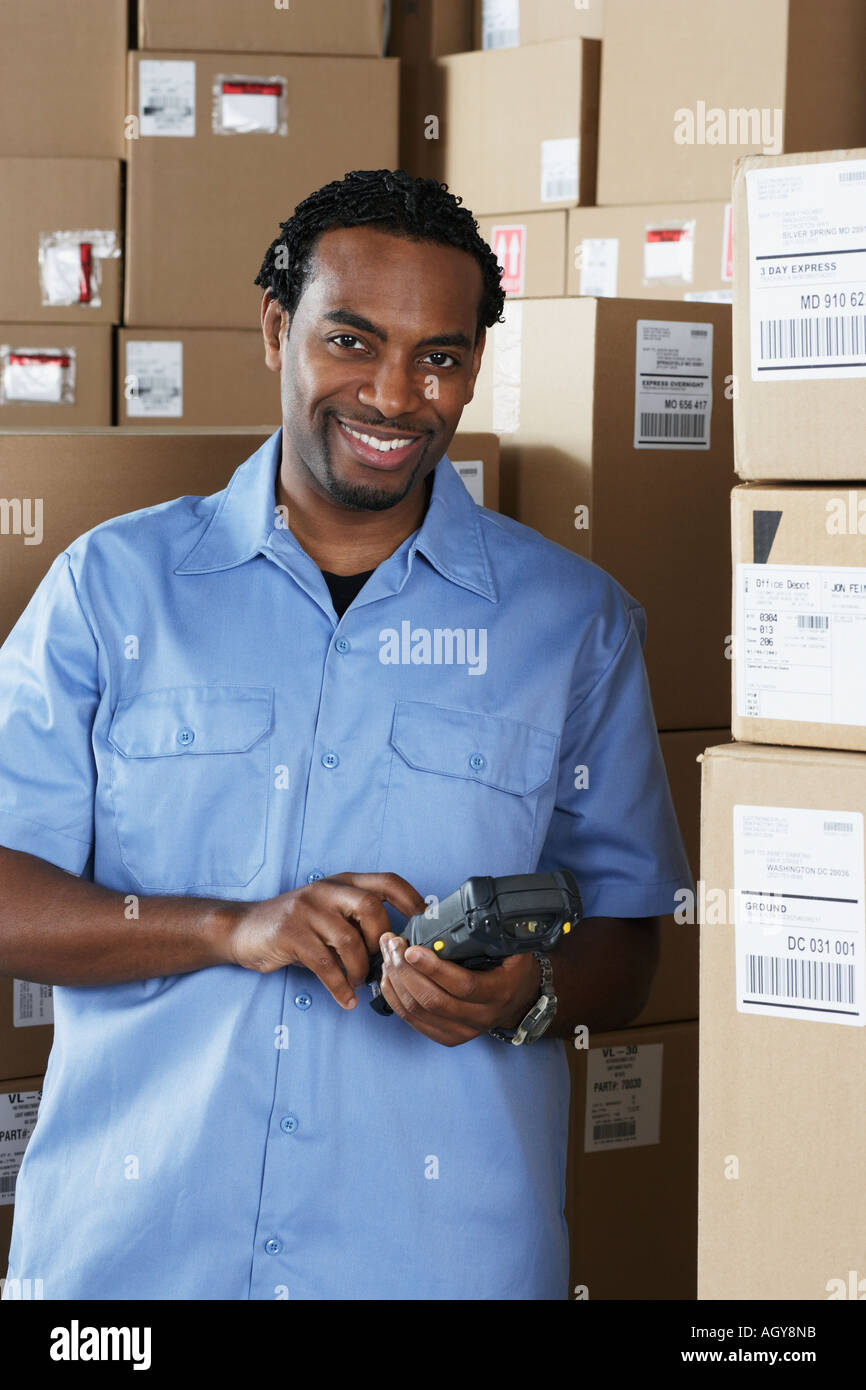 Male African warehouse worker scanning packages Stock Photo - Alamy