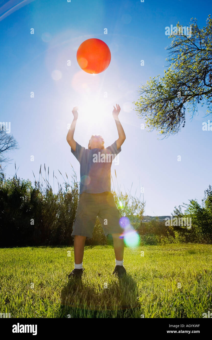 Boy throwing ball in bright sunlight Stock Photo - Alamy