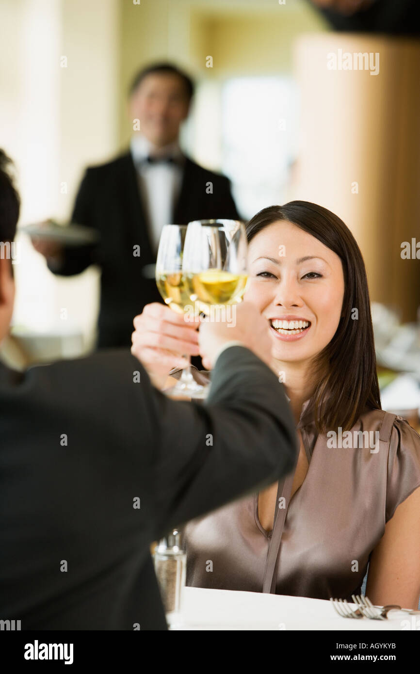 Asian woman toasting at restaurant Stock Photo - Alamy