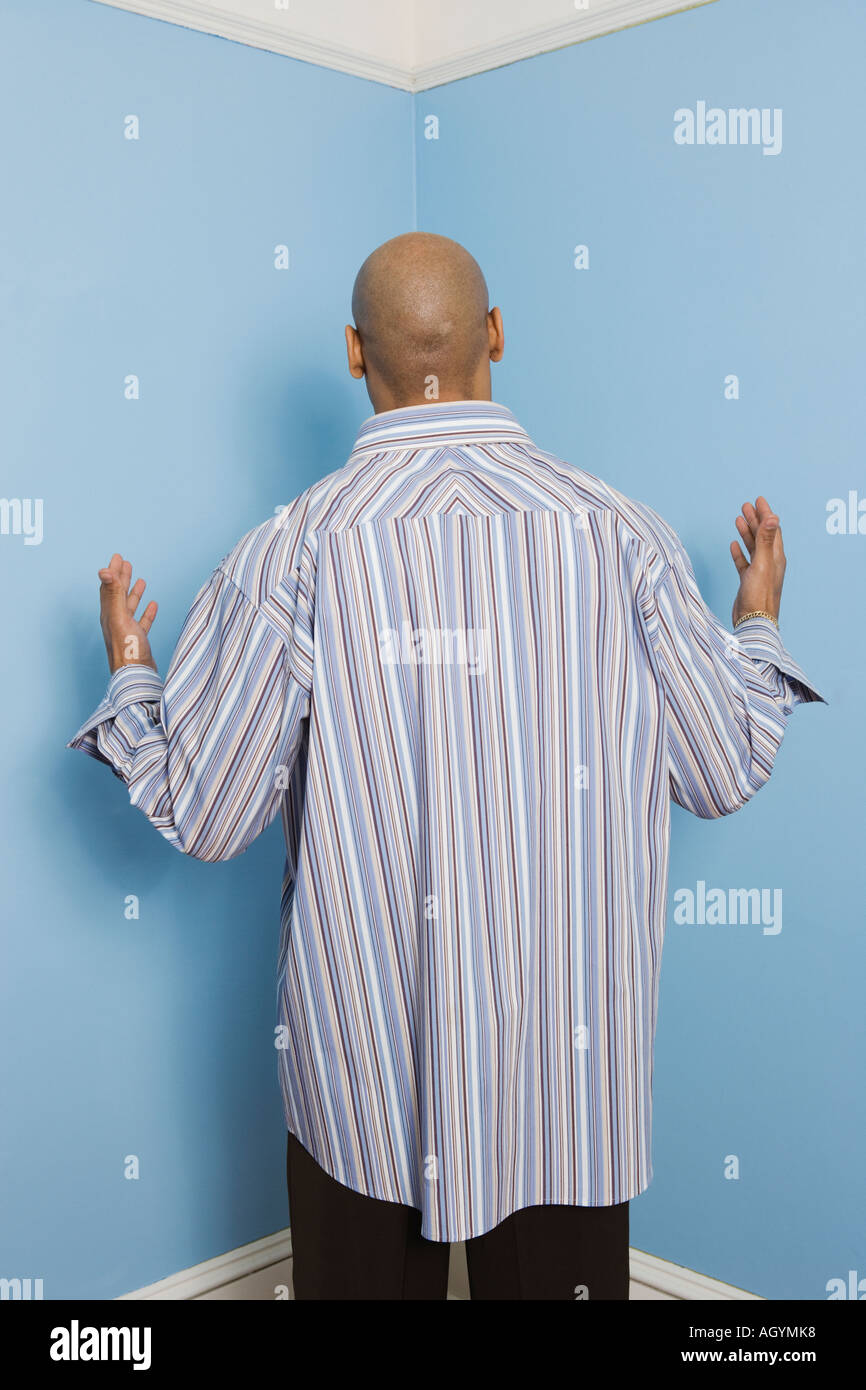 Rear view of African American man facing corner Stock Photo - Alamy