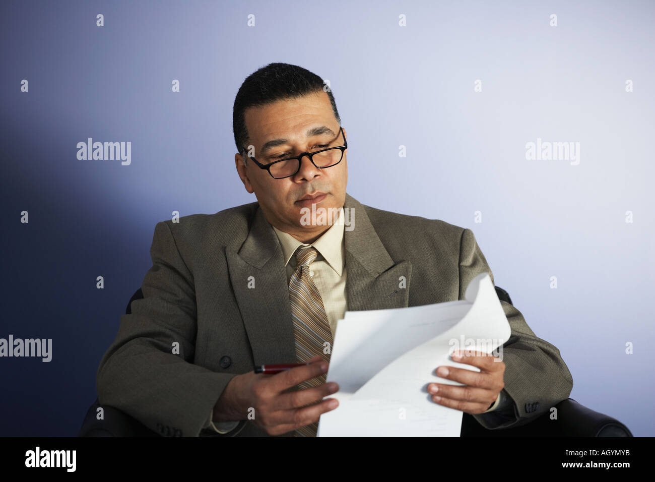 African American businessman reading paperwork Stock Photo - Alamy
