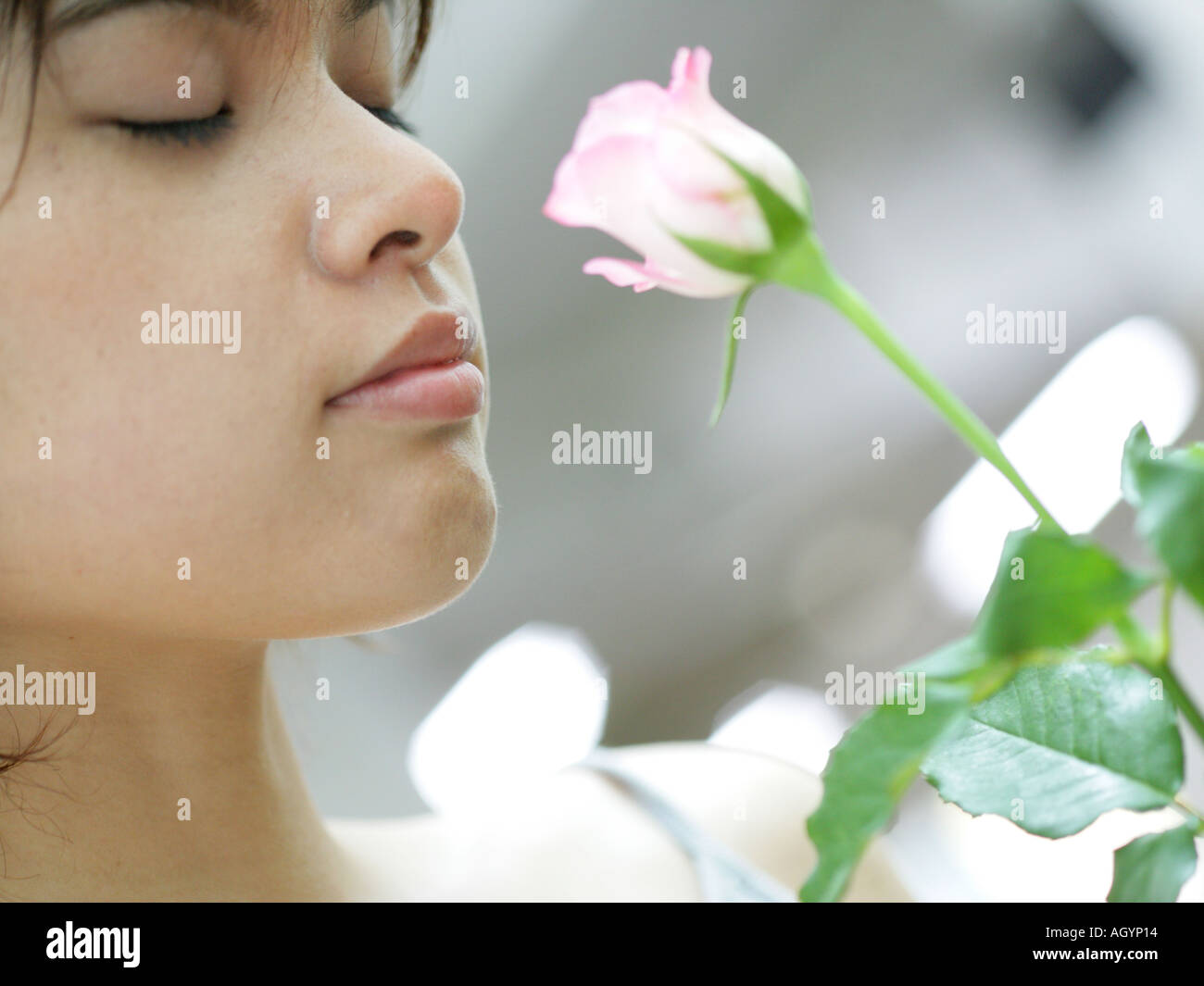 Side profile of a young woman praying with a flower in her hands Stock ...