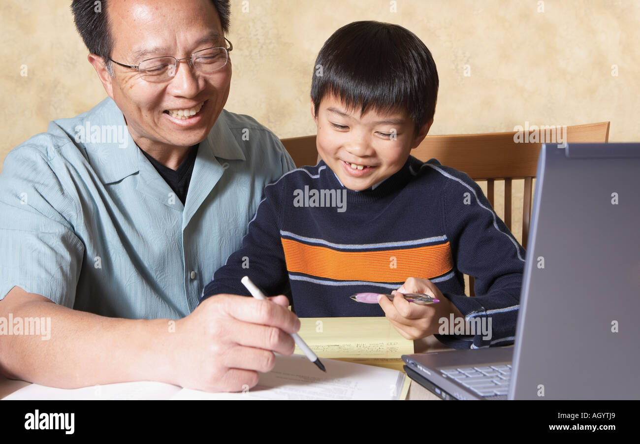 Asian father helping young son with homework Stock Photo - Alamy