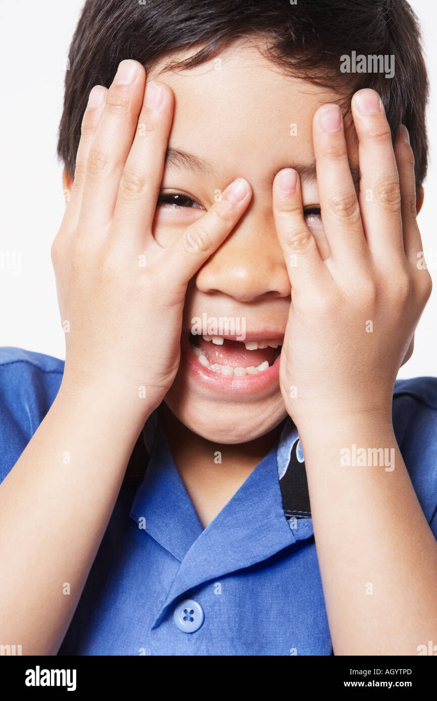 Young boy covering face with hands Stock Photo - Alamy