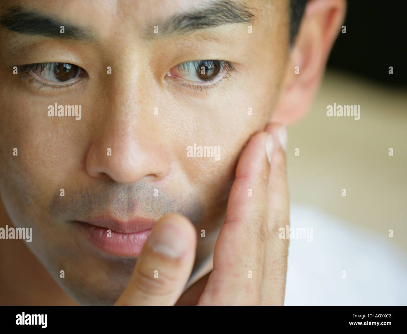 Close up of a mid adult man applying moisturizer on his cheek Stock Photo - Alamy