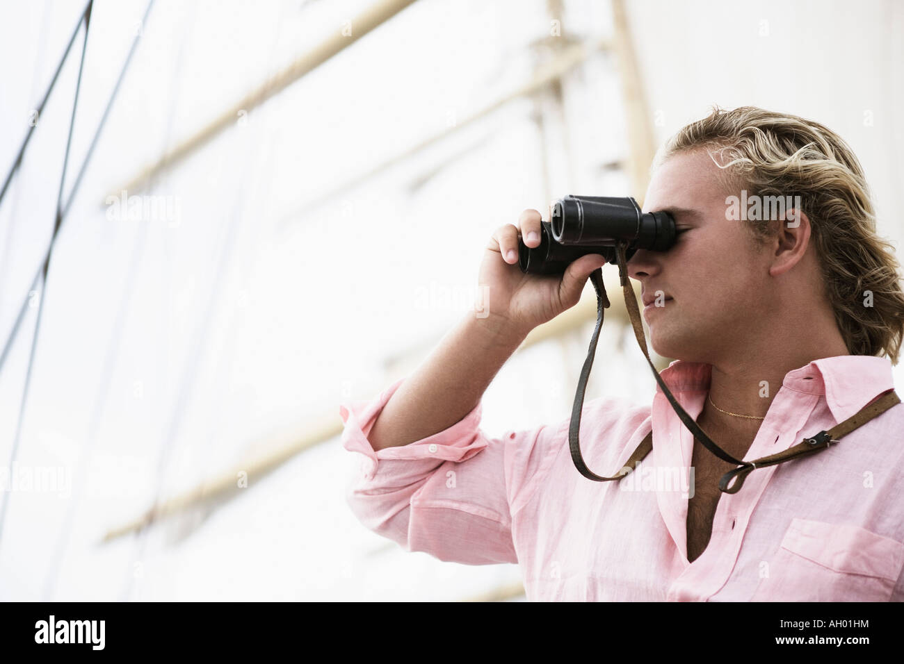 Close-up of a young man looking through binoculars Stock Photo - Alamy