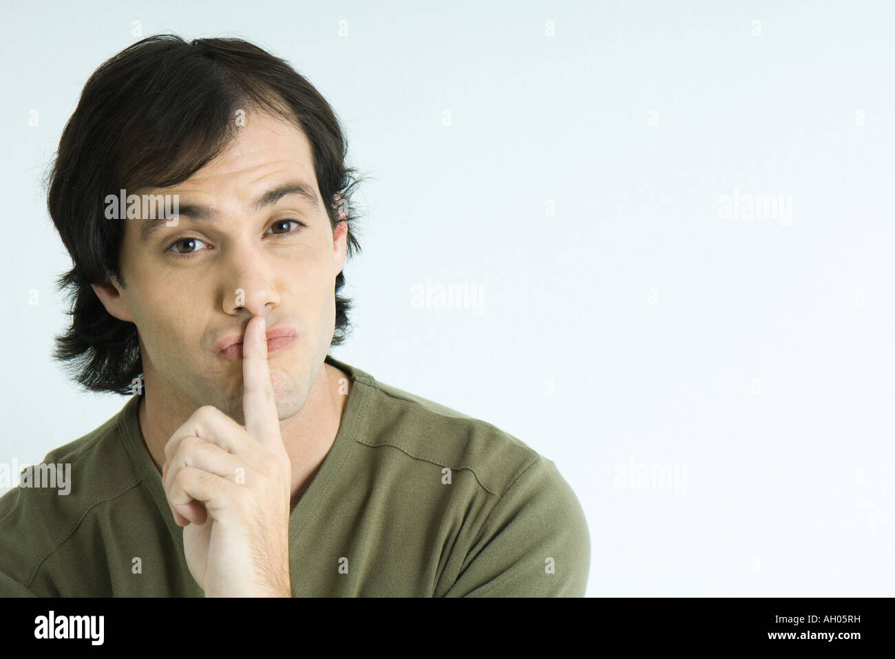 Man with finger over lips, portrait Stock Photo - Alamy