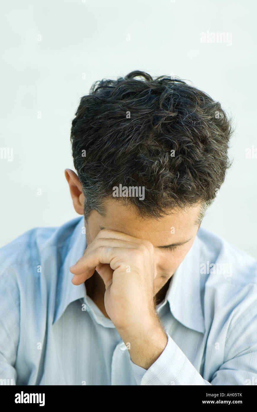 Man leaning head against fist, portrait Stock Photo - Alamy