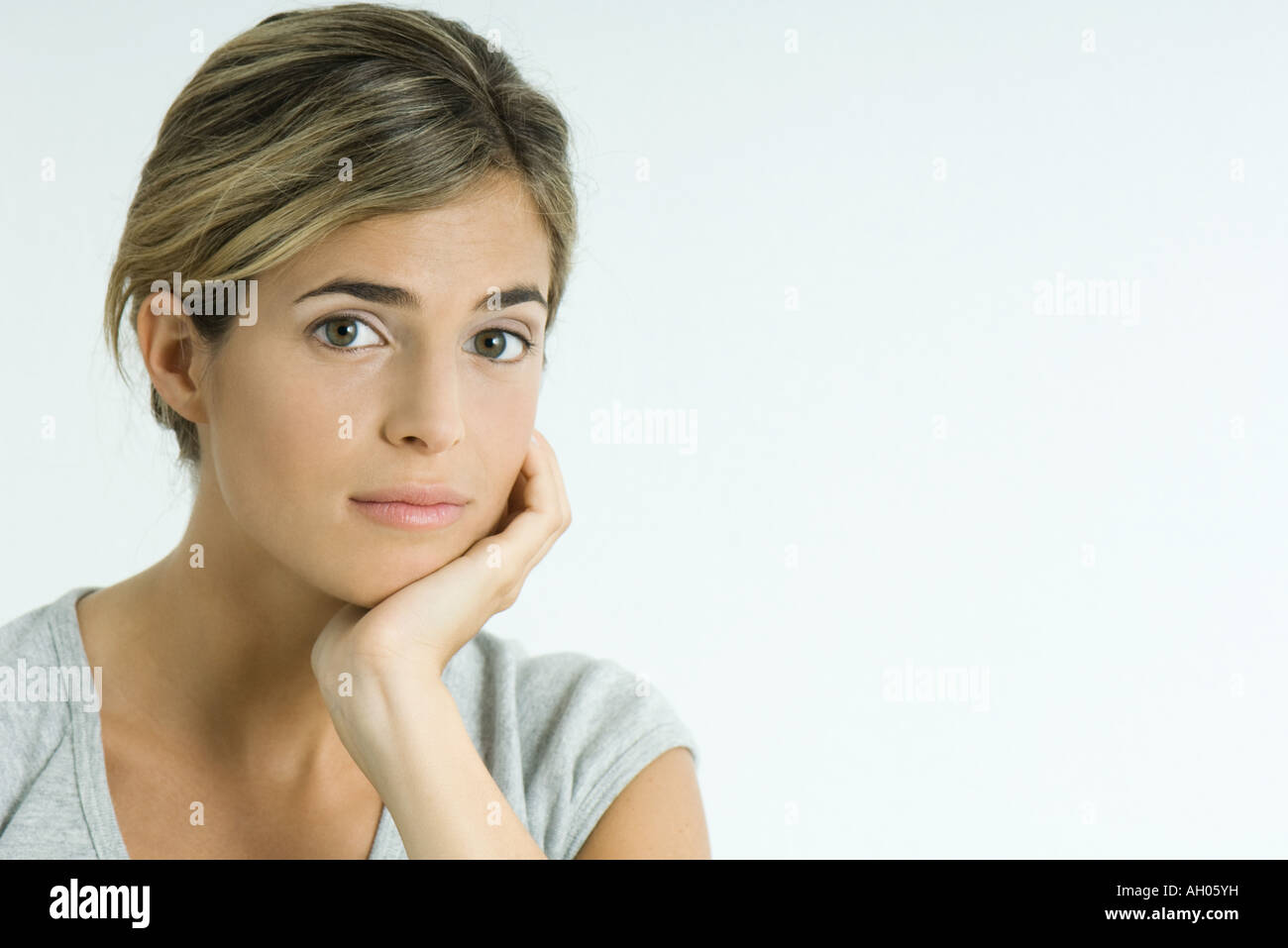 Young woman leaning head on hand, portrait Stock Photo - Alamy