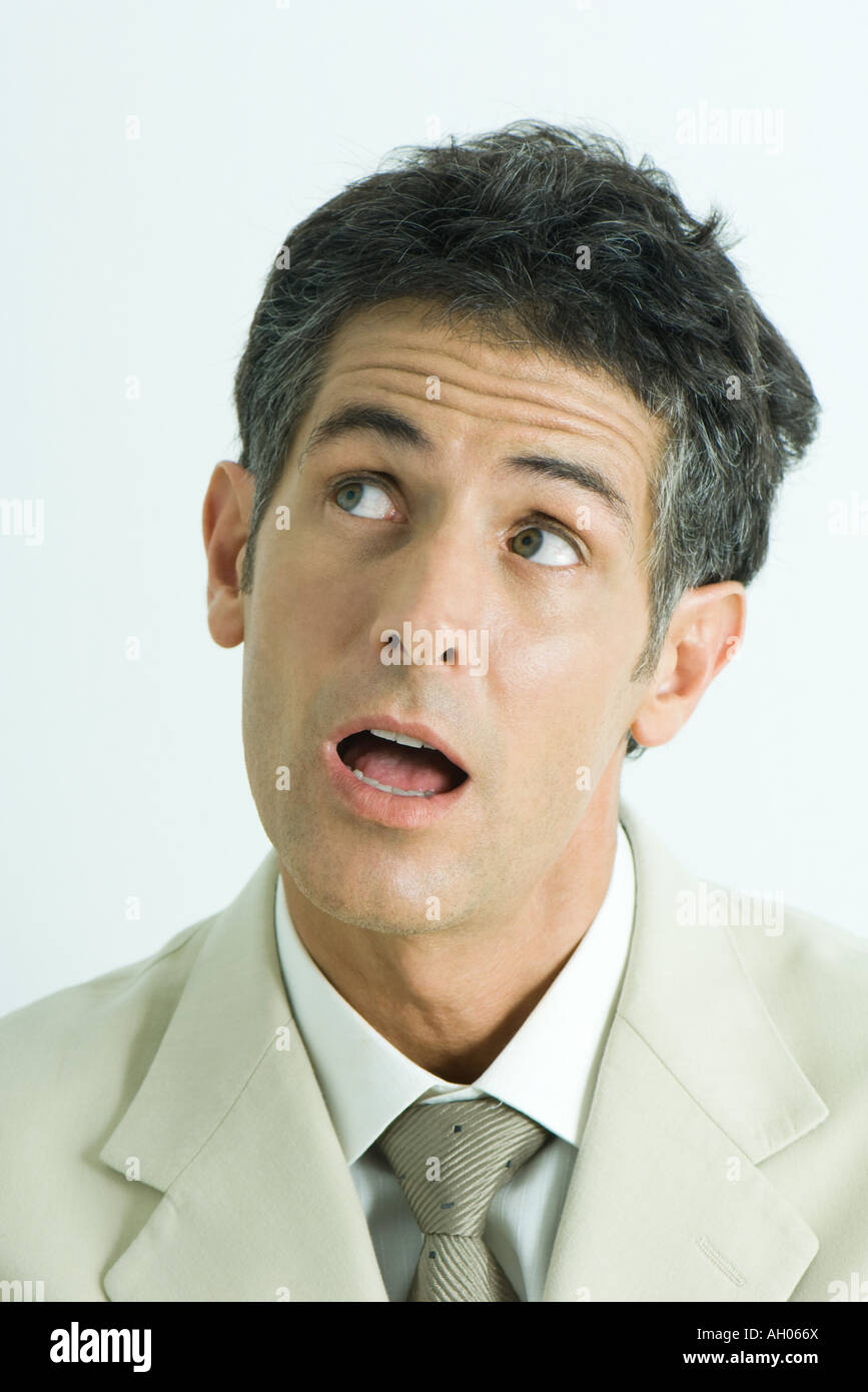 Businessman raising eyebrows, looking to the side, mouth open, portrait ...