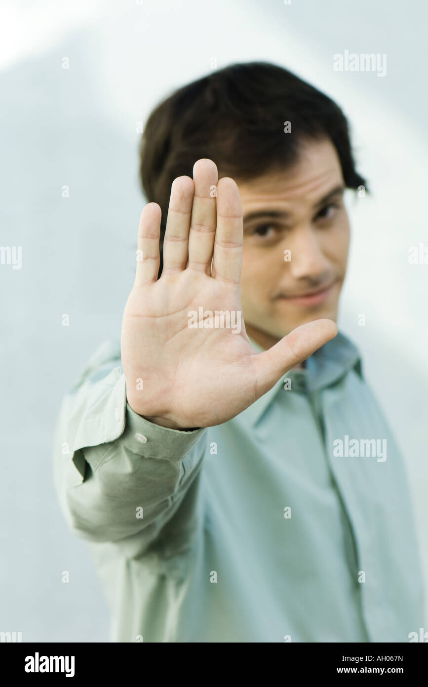 Man holding up palm to camera, portrait Stock Photo - Alamy