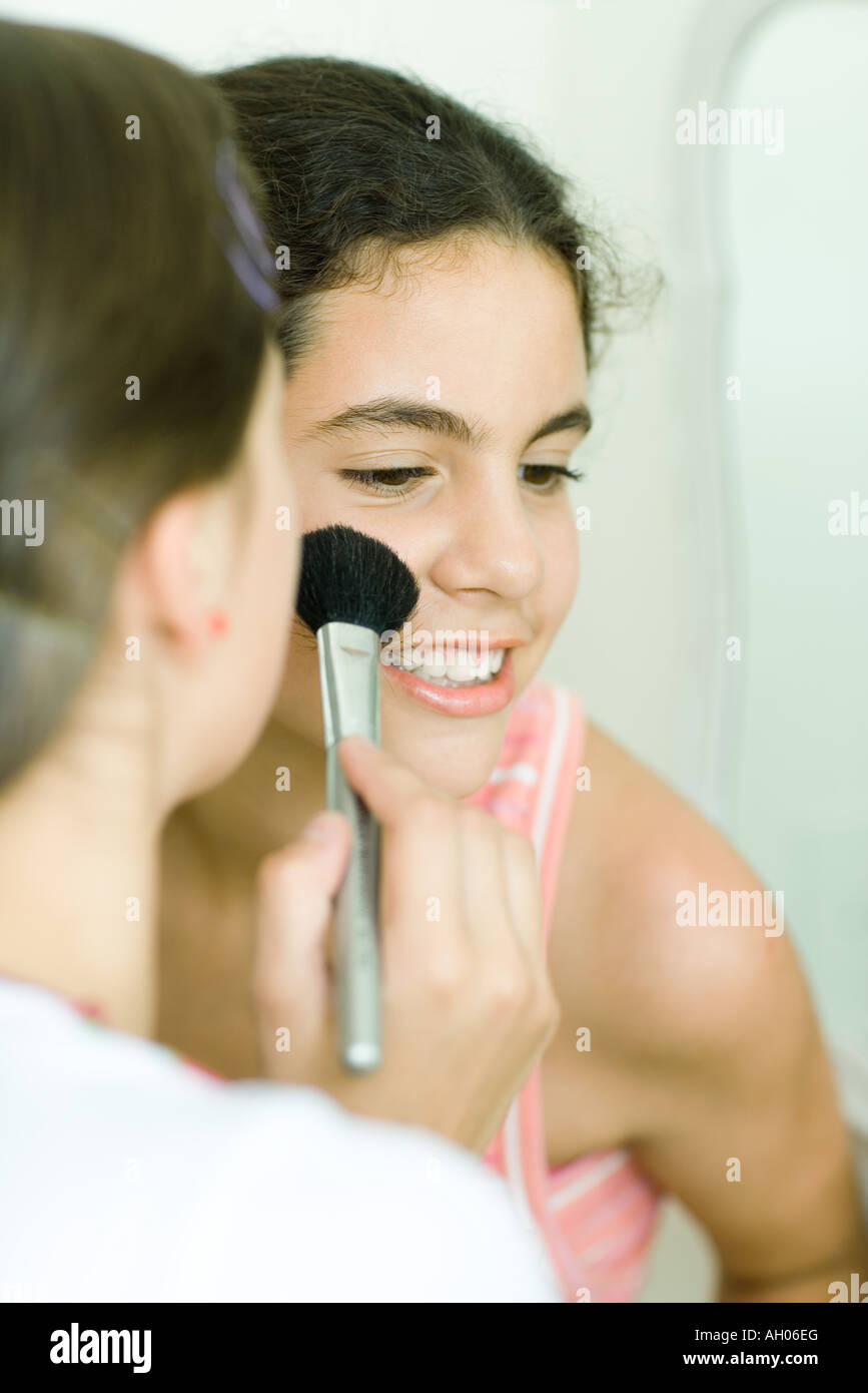 Two young female friends, one putting make-up on the other Stock Photo ...